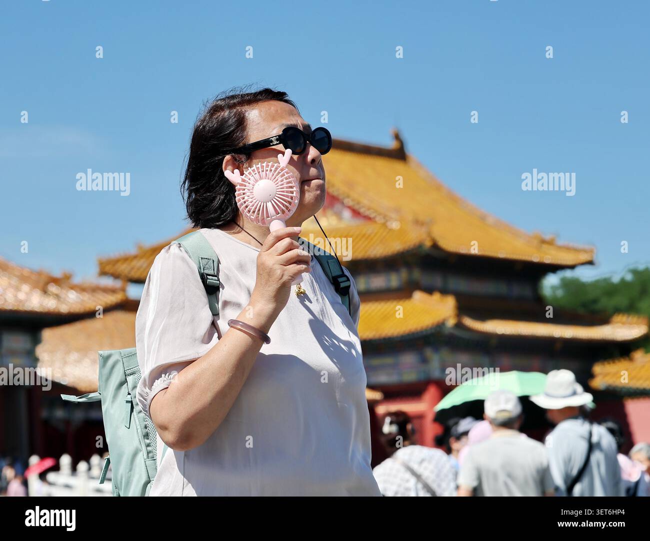 Tourists use various sun protection methods at the Forbidden City in ...