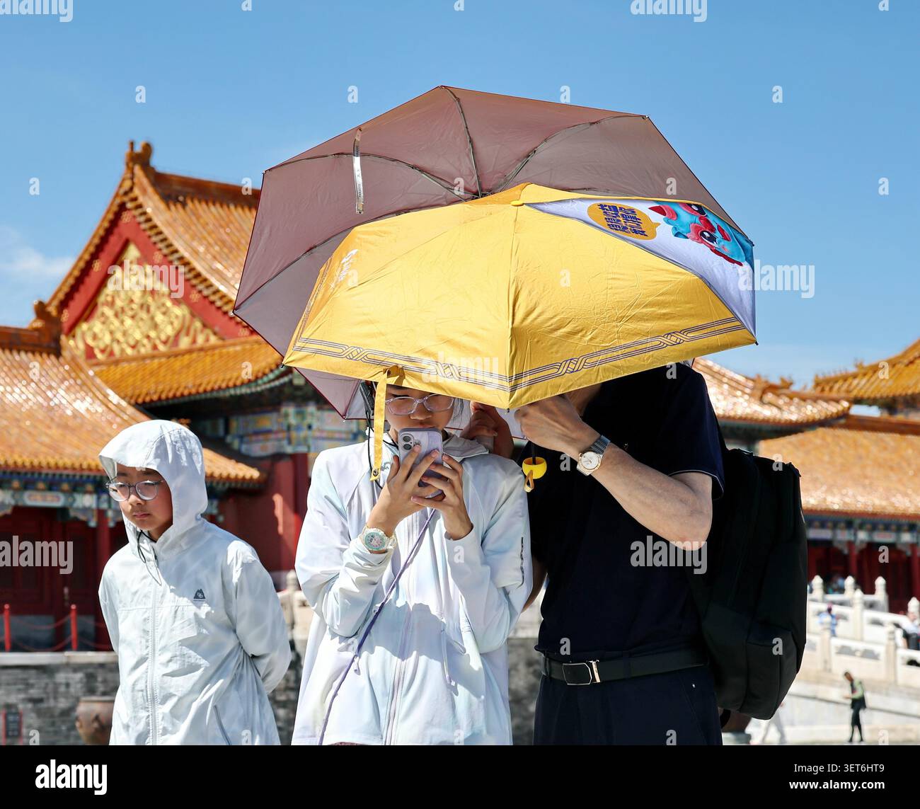 Tourists use various sun protection methods at the Forbidden City in ...