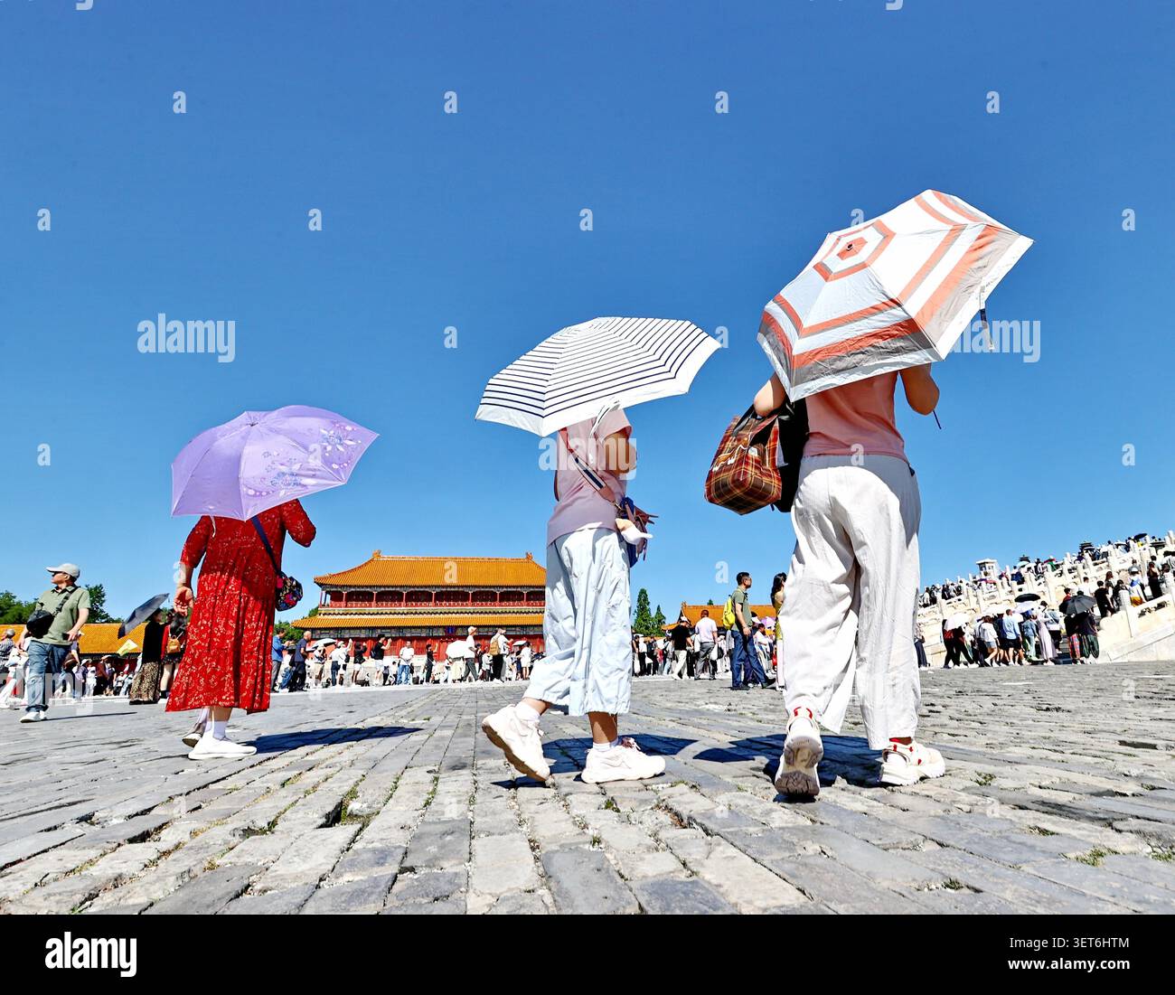 Tourists use various sun protection methods at the Forbidden City in ...