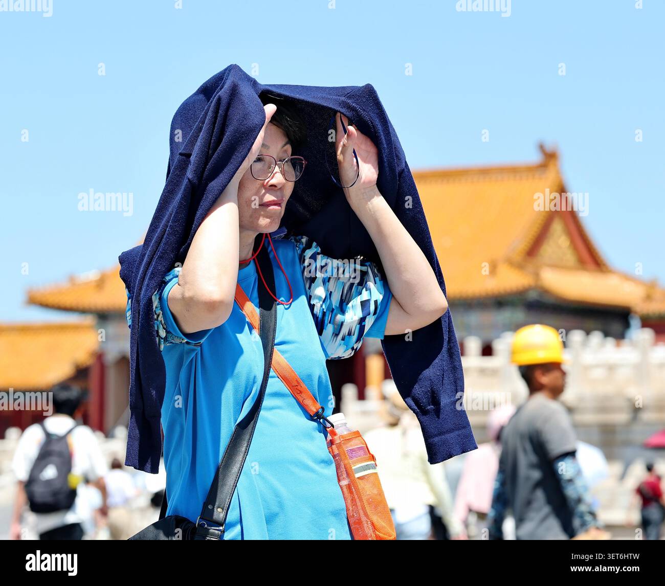 Tourists use various sun protection methods at the Forbidden City in ...
