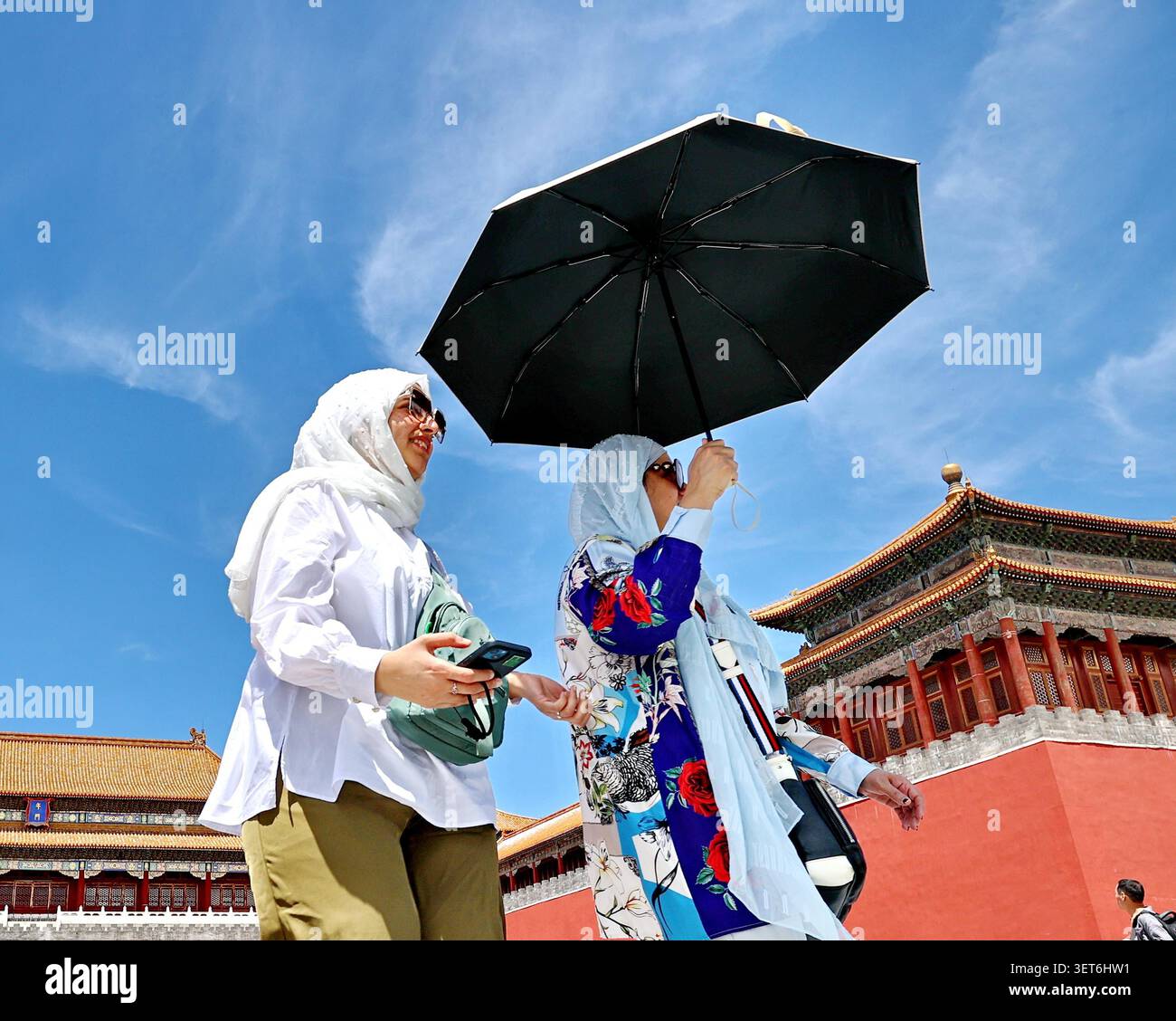 Tourists use various sun protection methods at the Forbidden City in ...