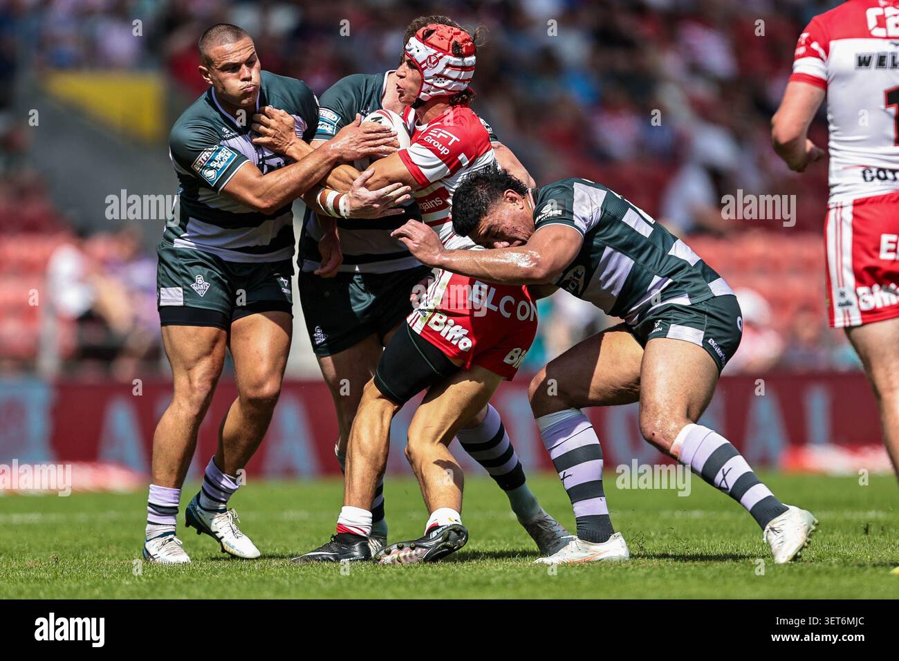 Harry Robertson is tackled by Zac Woolford and Chris Patolo during the ...