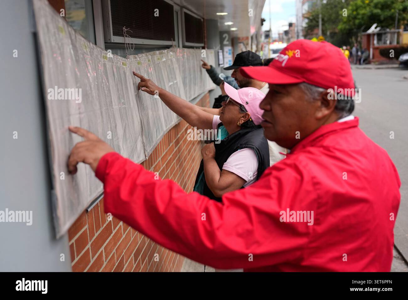 Voters check electoral lists during the runoff election in Bogota ...
