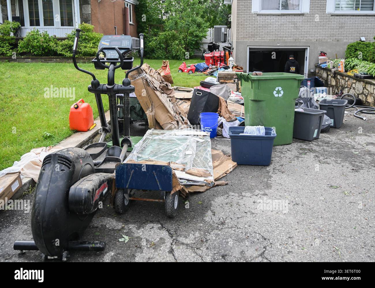 Exercise equipment and other belongings are shown outside a flooded ...