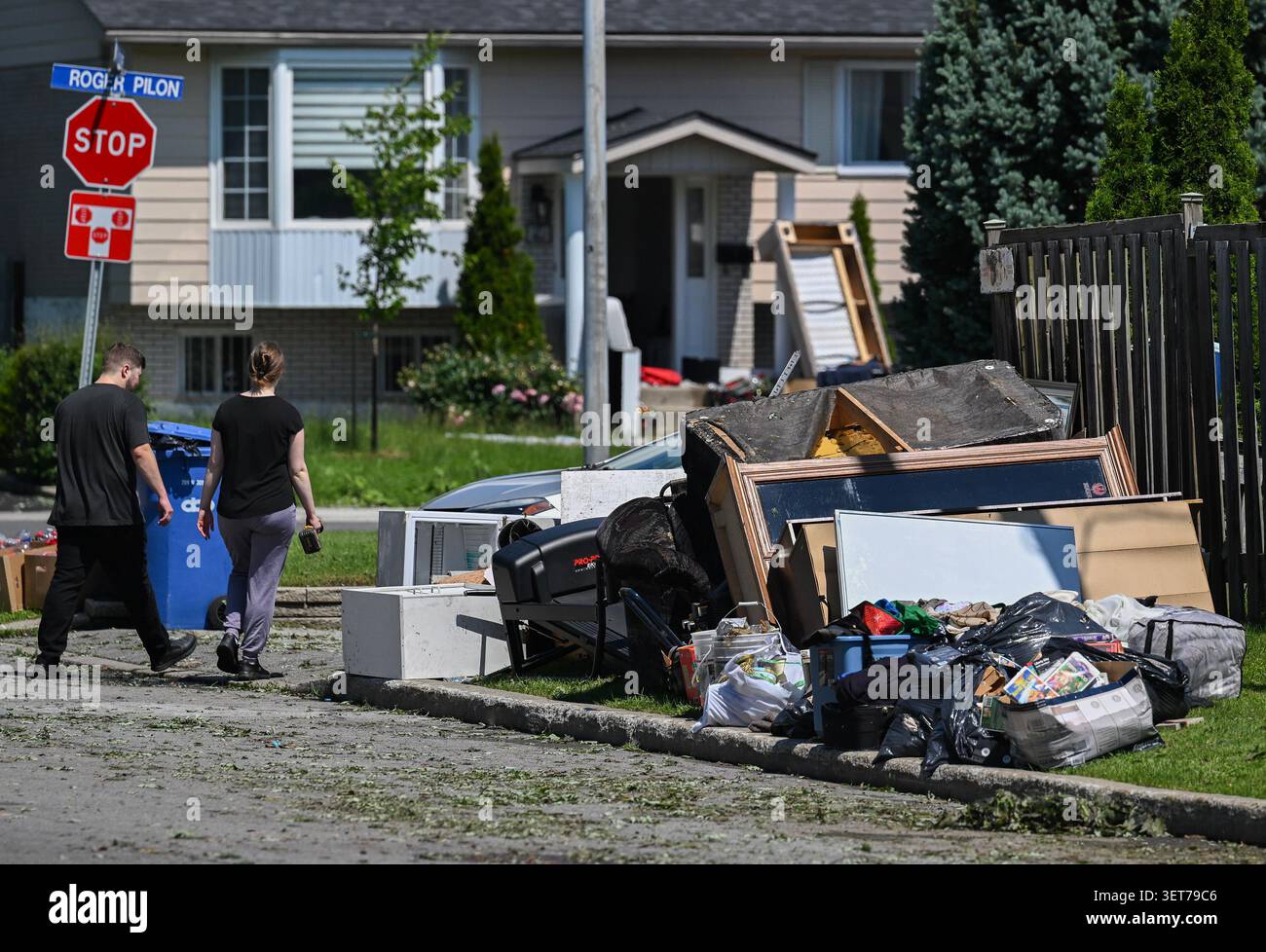 Furniture and other household belongings are shown on a street in the ...