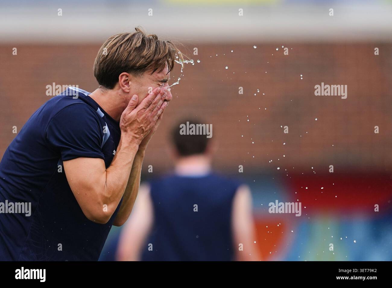 Austria's Michael Svoboda refreshes himself from water off a sprinkler ...