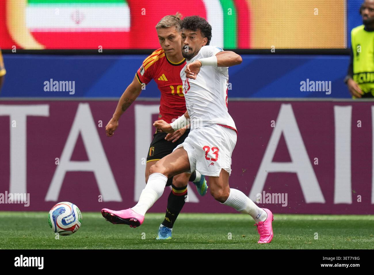 Iran's Ramin Rezaeian, front, kicks the ball past Belgium's Leandro ...