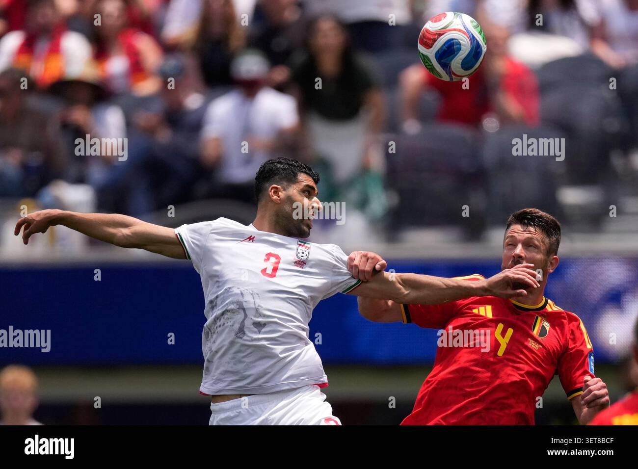 Iran's Mehdi Taremi (9) and Belgium's Brandon Mechele go for a header ...