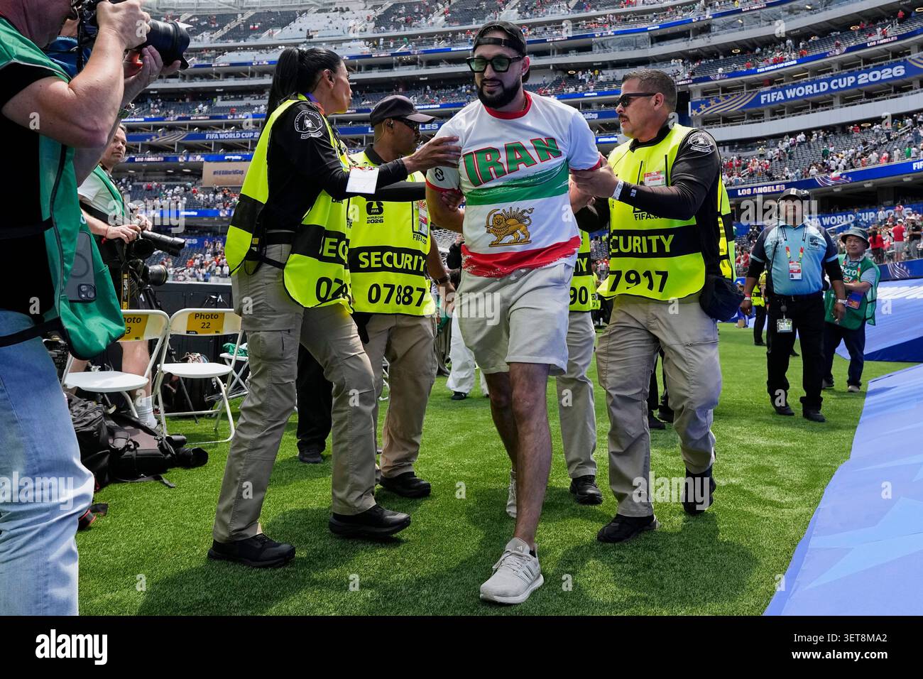 An Iranian fan is removed from the pitch by security at the end of the ...