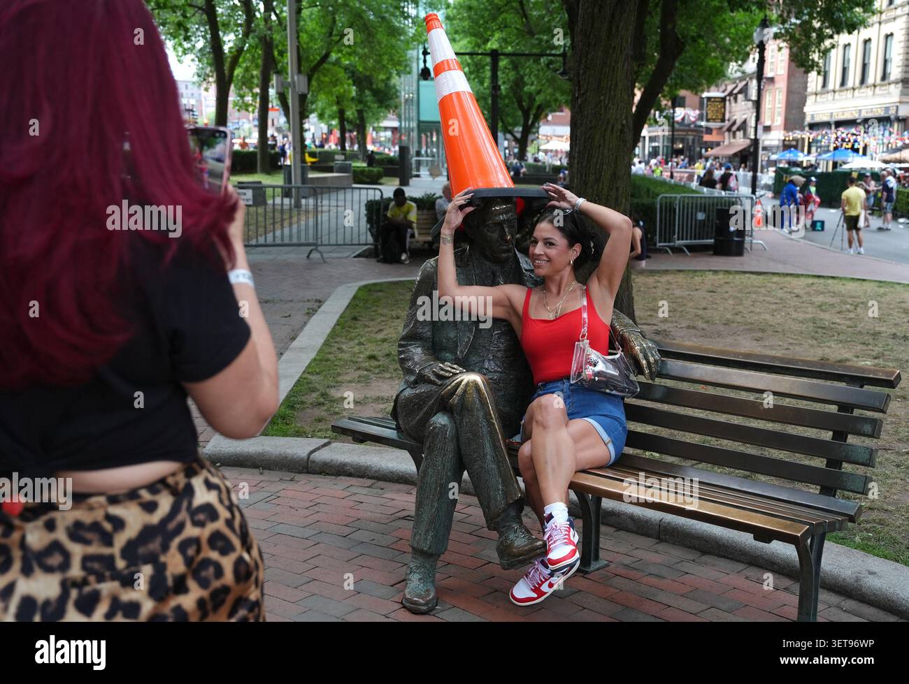 A Statue in James Michael Curley Park wears a traffic cone as people ...