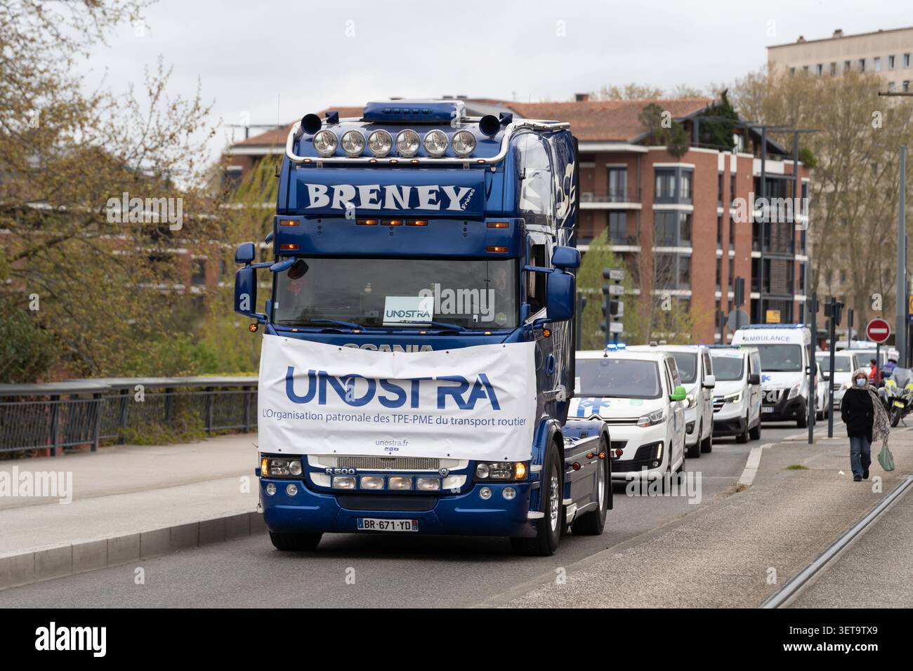 Blue truck with Unostra union sign followed by a convoy of ambulances ...