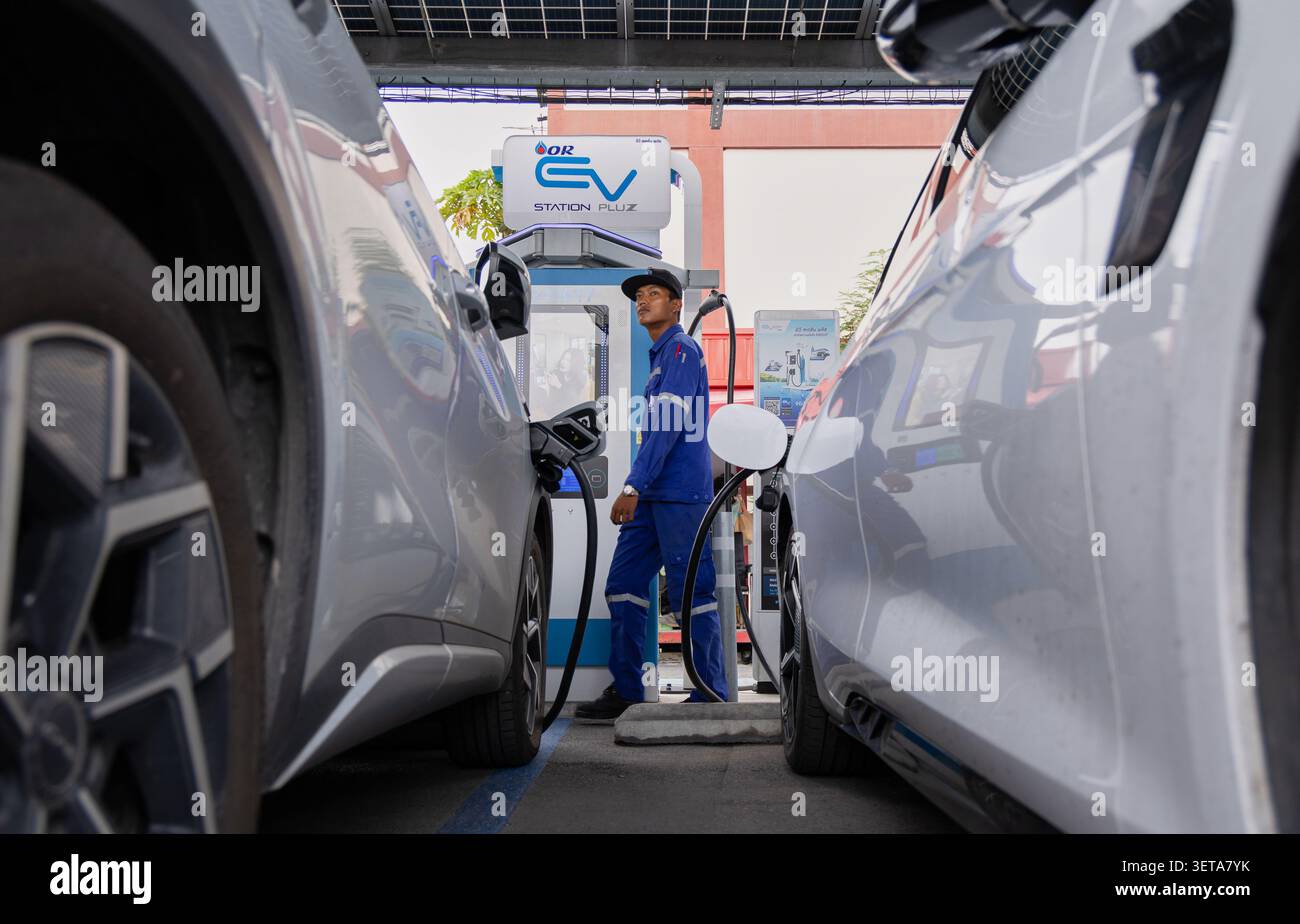 Khatawut Junsongsaeng, a charging station manager, walks past two ...