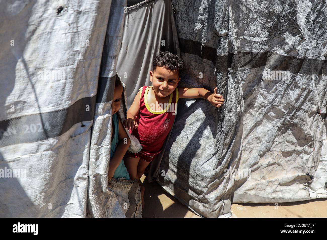 Palestinian children bathe in their tent inside a displacement camp in ...