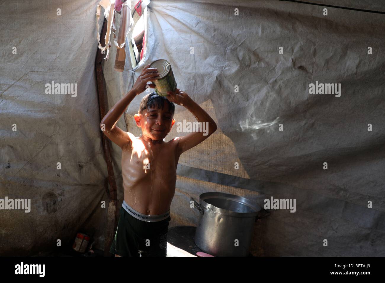 Palestinian children bathe in their tent inside a displacement camp in ...
