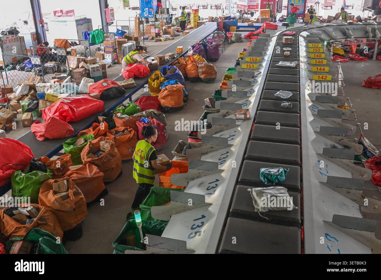 WEIFANG, CHINA - JUNE 18, 2026 - Workers work on a parcel sorting line ...