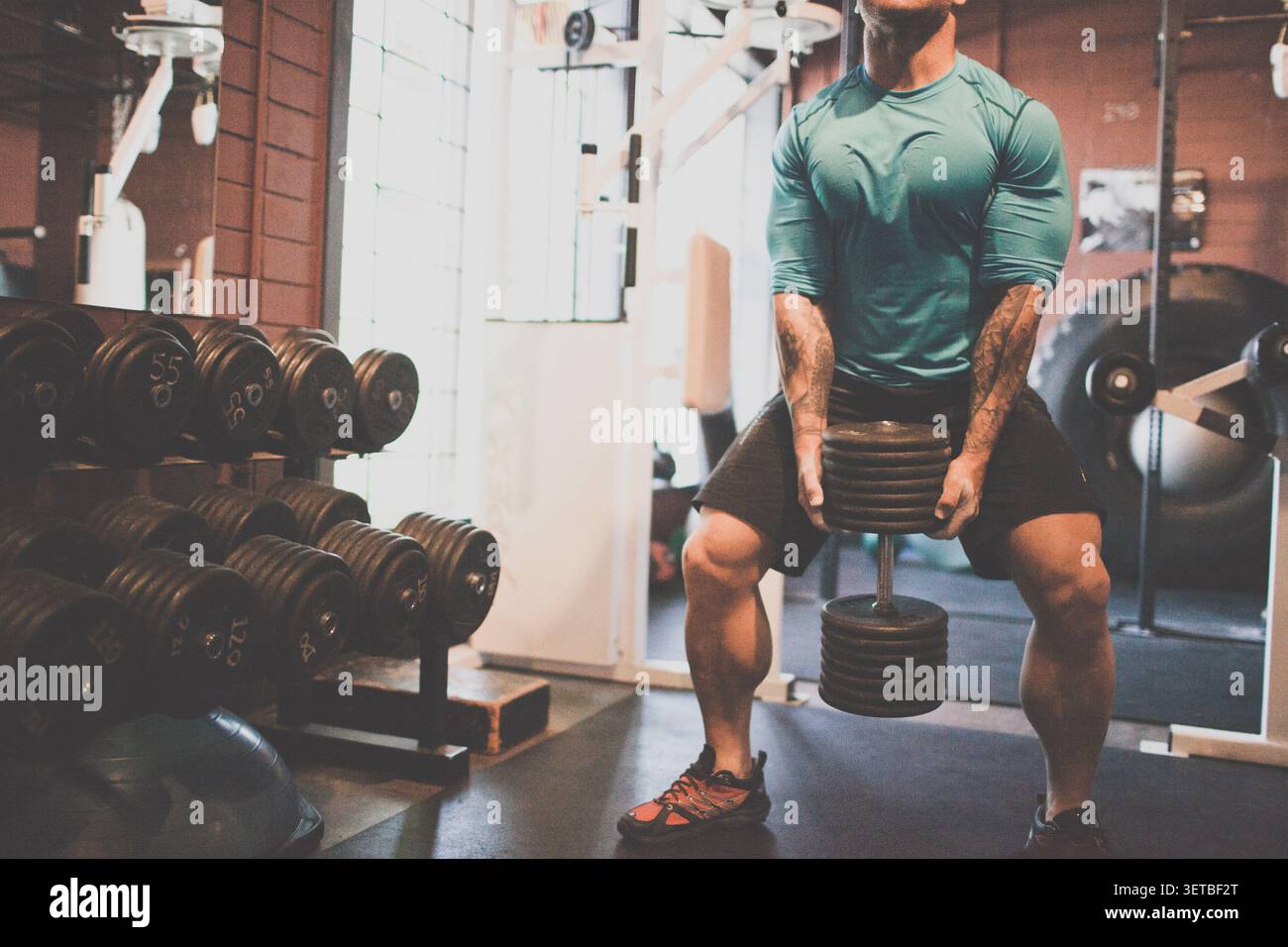 Adam Palmer, a mountain athlete, preforms squats with a dumbbell Stock ...