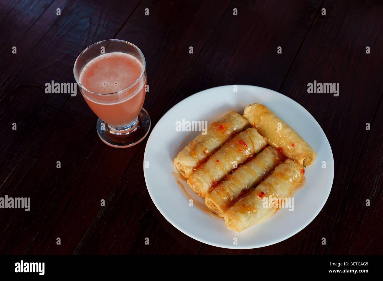 Five golden brown fried spring rolls drizzled with spicy sweet chili ...