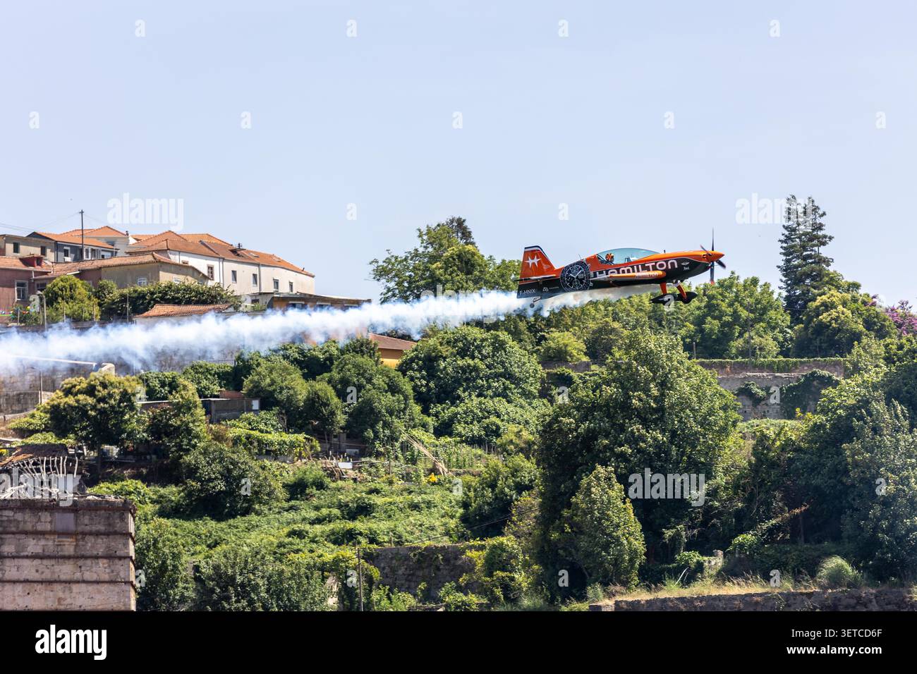 A Hamilton-branded aerobatic aircraft performs a low?altitude manoeuvre ...