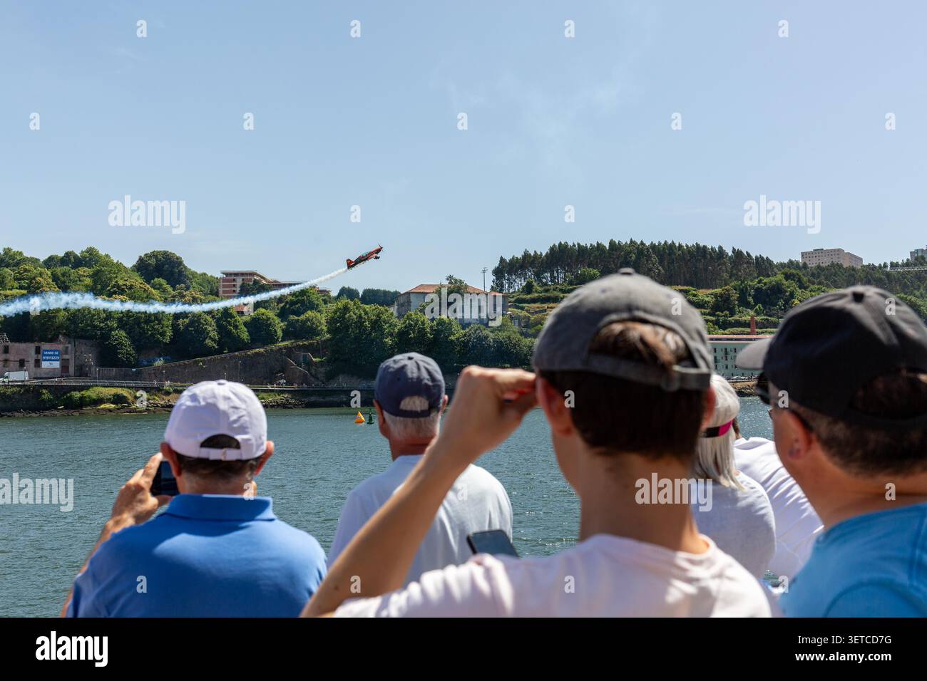 Spectators watch as a Hamilton?branded aerobatic aircraft climbs during ...
