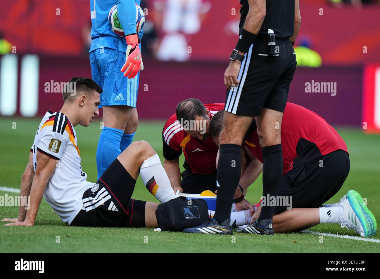 Germany's Nico Schlotterbeck receives treatment following an injury ...