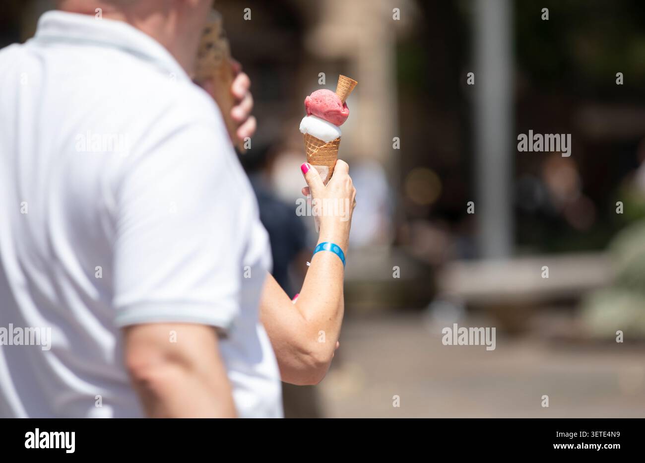 22 June 2026, Spain, Palma: A woman is enjoying an ice cream under the ...