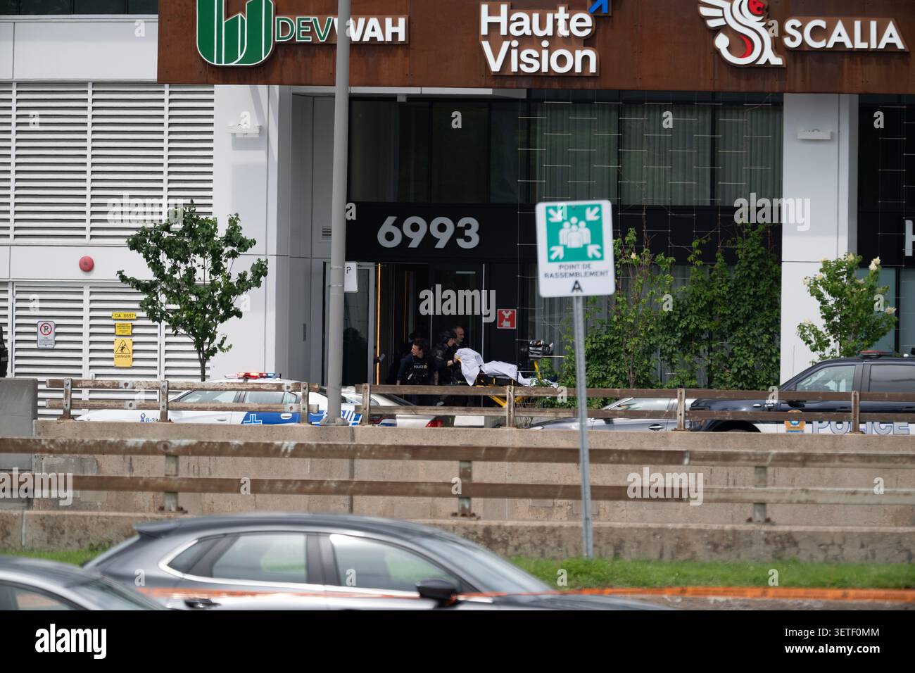 A stretcher is pushed out of a building as police respond to a shooting ...