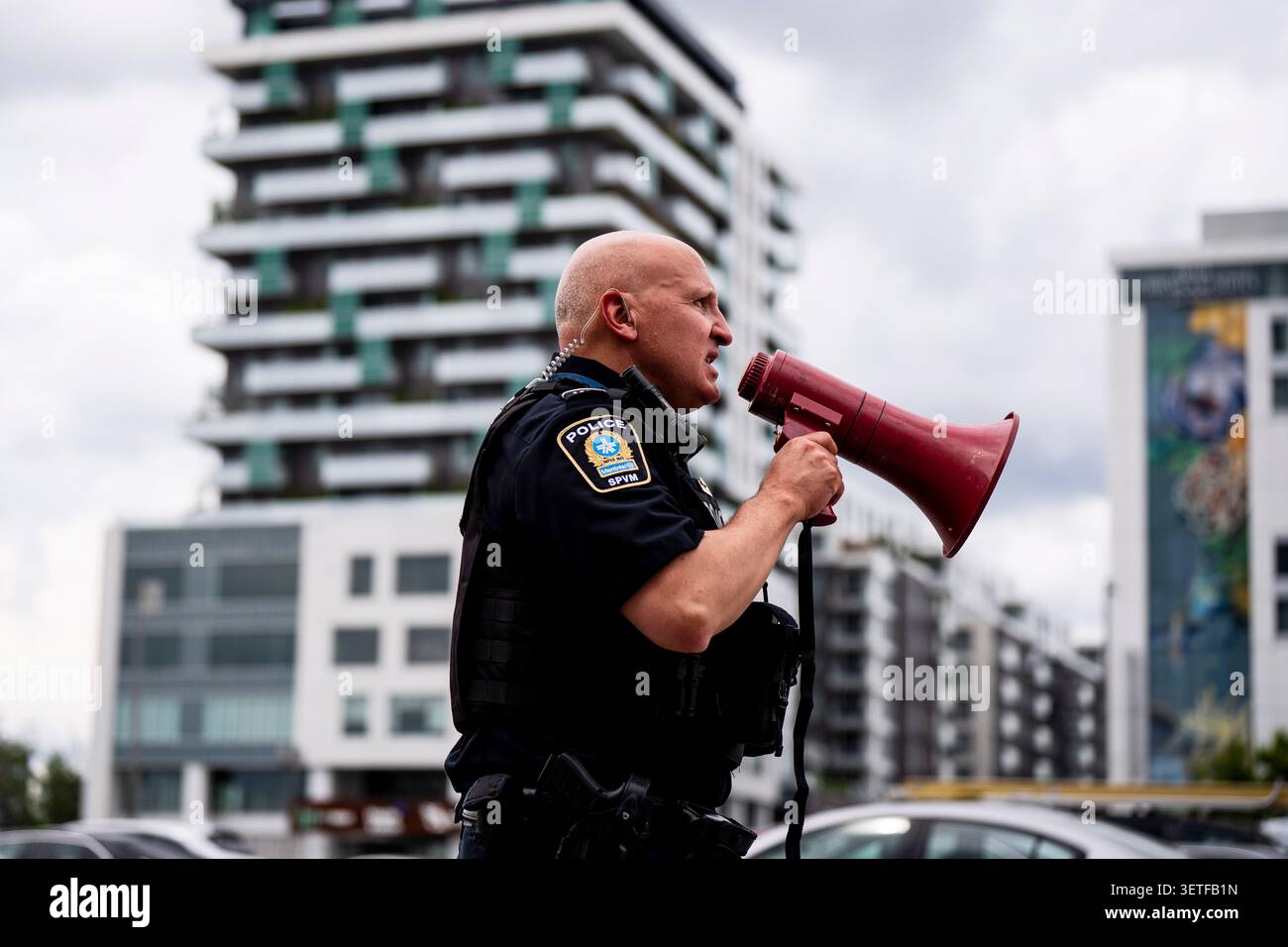 A Montreal police officer clears an area at the scene of a shooting in ...
