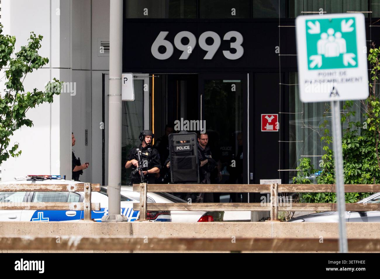Montreal police exit a building at the scene of a shooting in Montreal ...