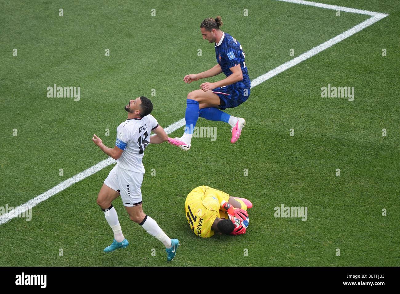 France's Adrien Rabiot (14) leaps over teammate and goalkeeper Mike ...