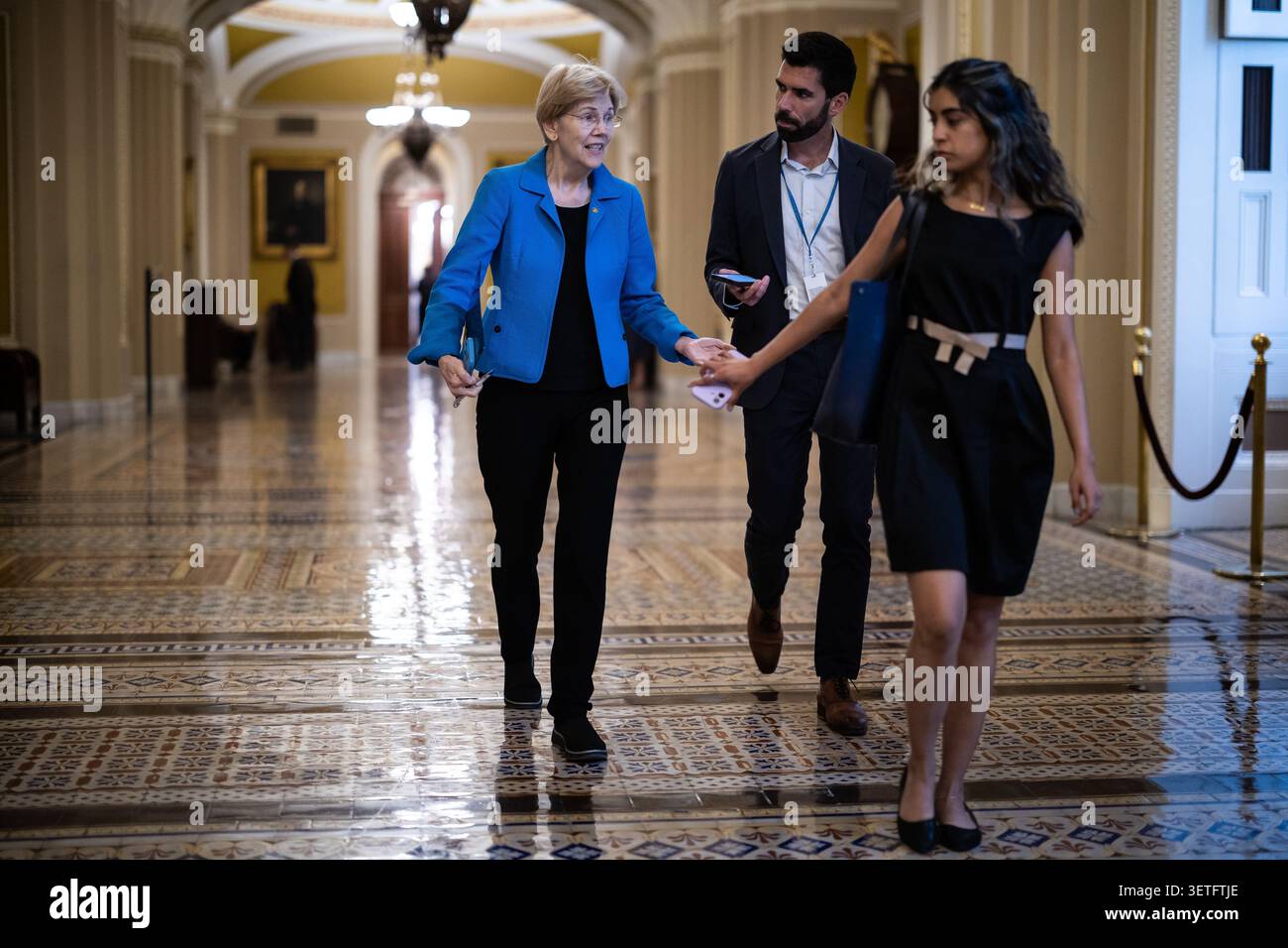 Sen. Elizabeth Warren (D-Mass.) walks with a reporter and an aide on ...