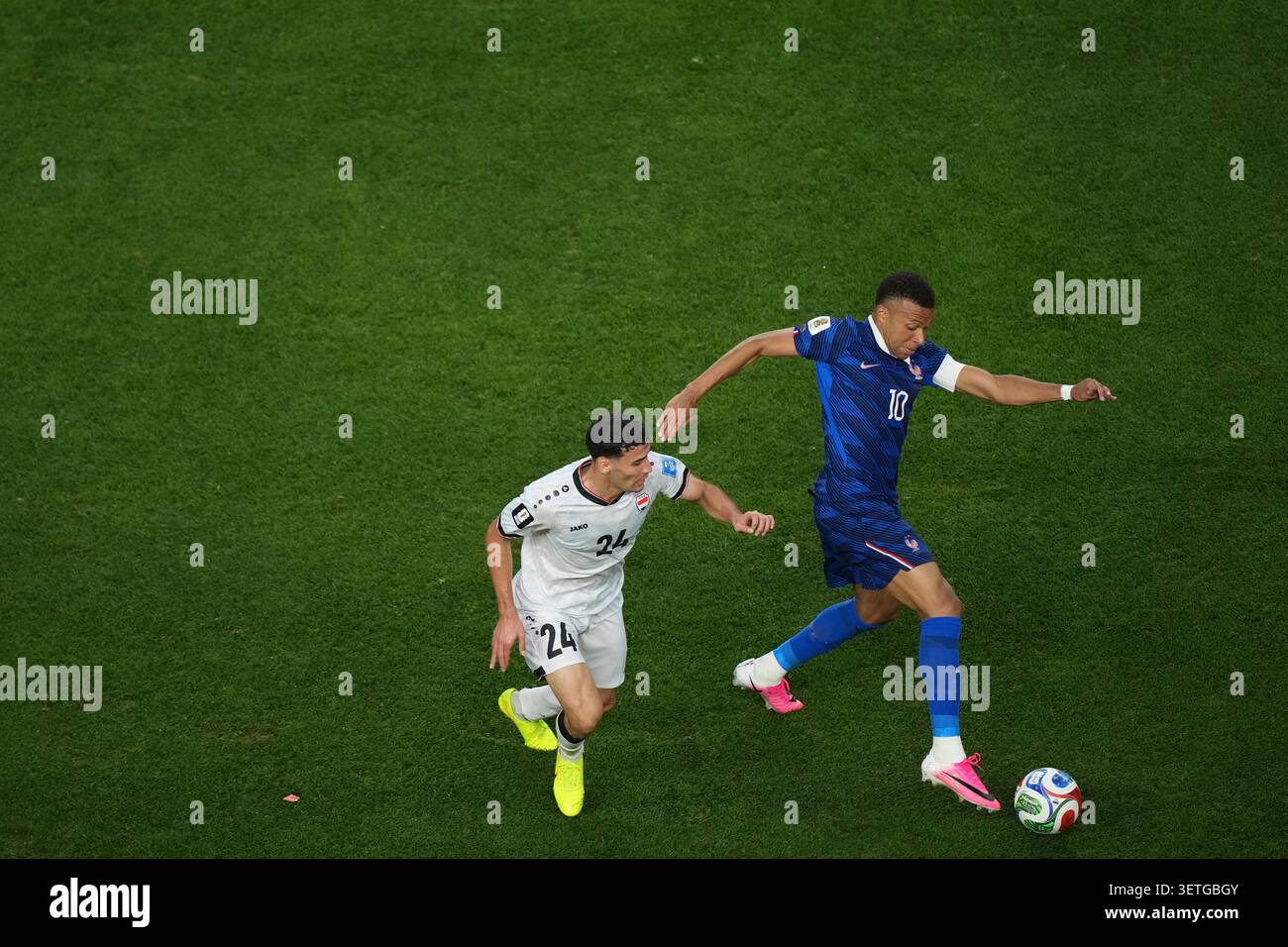 France's Kylian Mbappe, right, runs with the ball past Iraq's Zaid ...