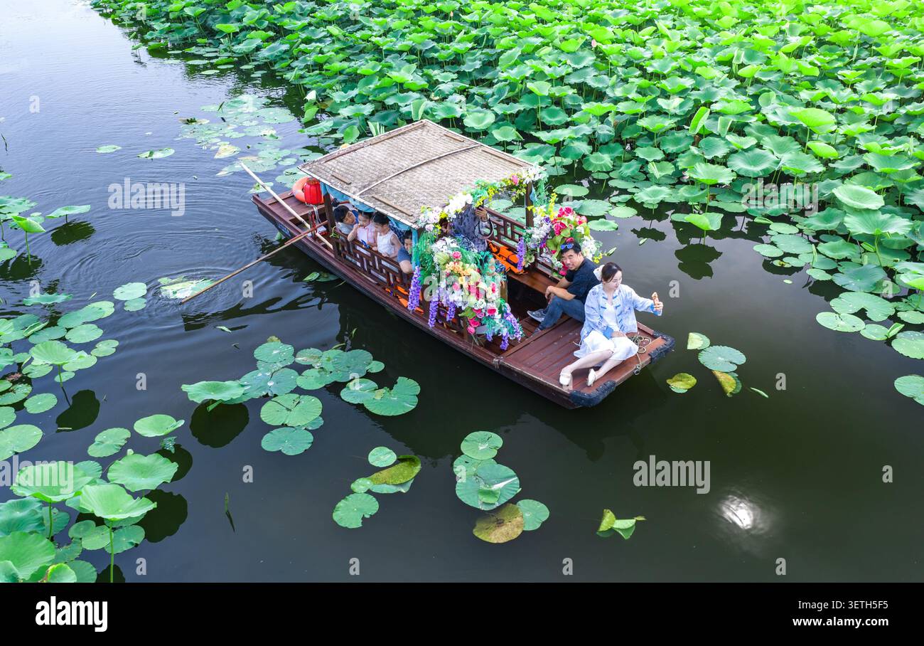 Tourists ride rafts through lotus-filled waterways in Xinghua, east ...
