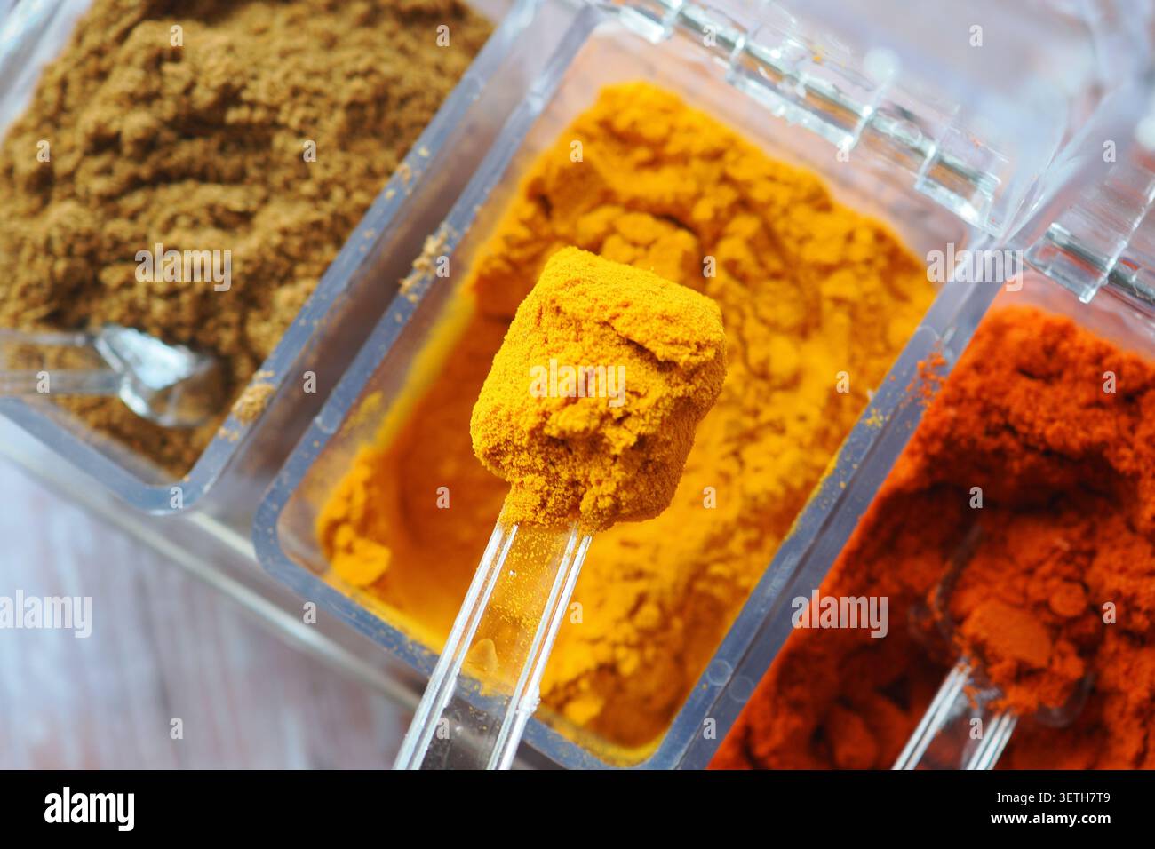 Different spices in clear containers on a table Stock Photo - Alamy