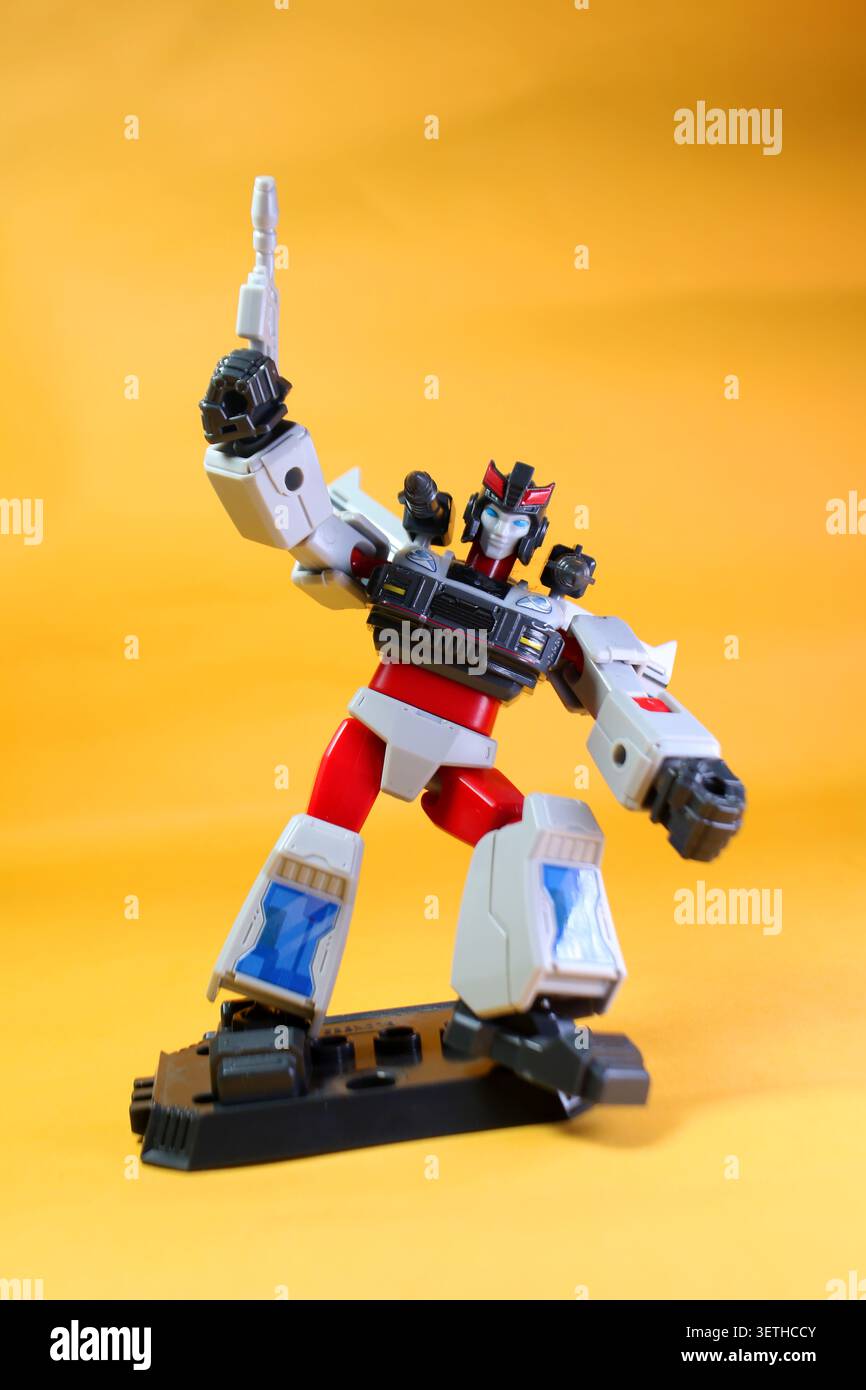 Pose of a transforming robot car toy, isolated on a n orange background ...