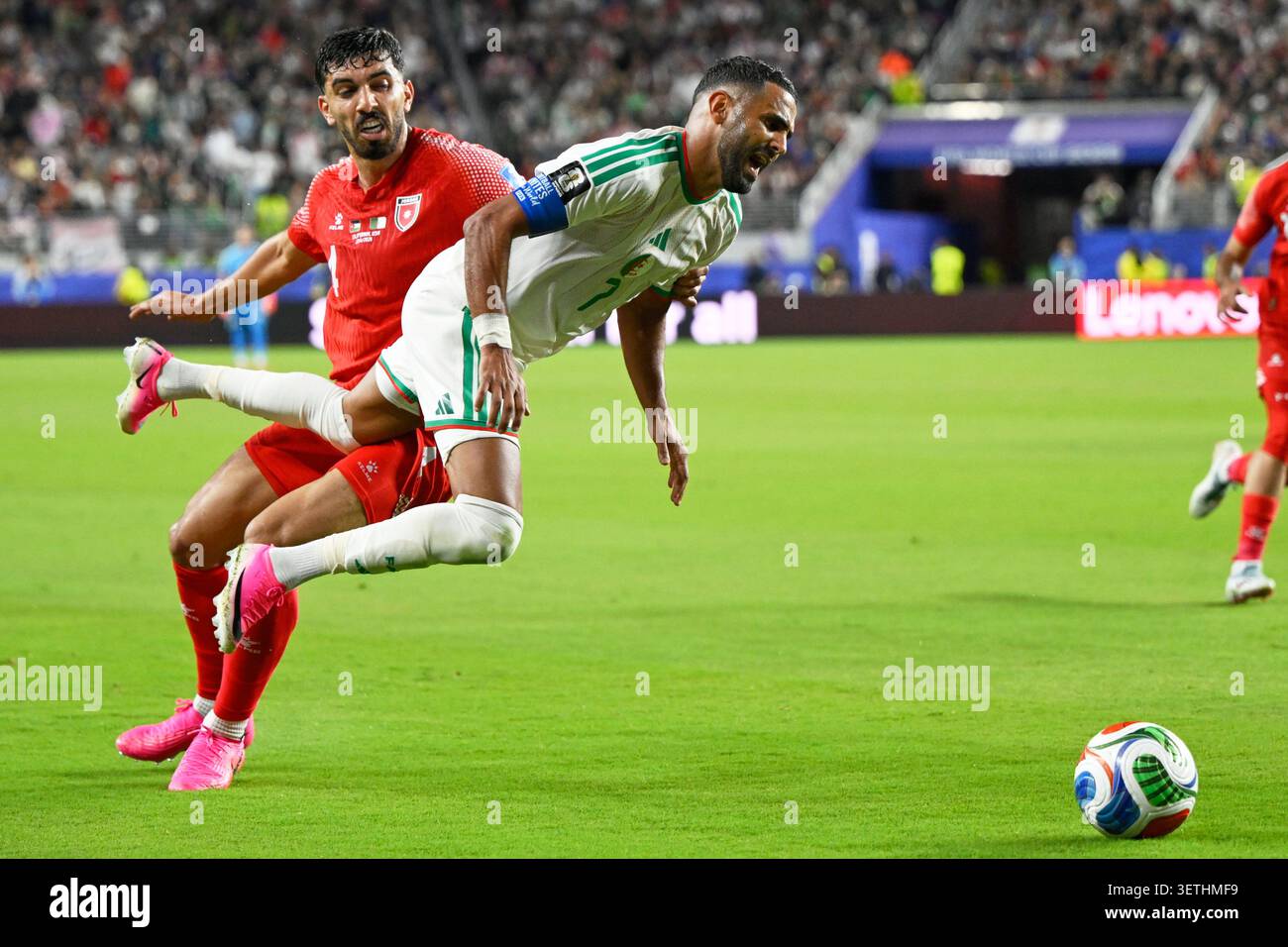 Algeria's Riyad Mahrez, right, is tackled by Jordan's Husam Abudahab ...