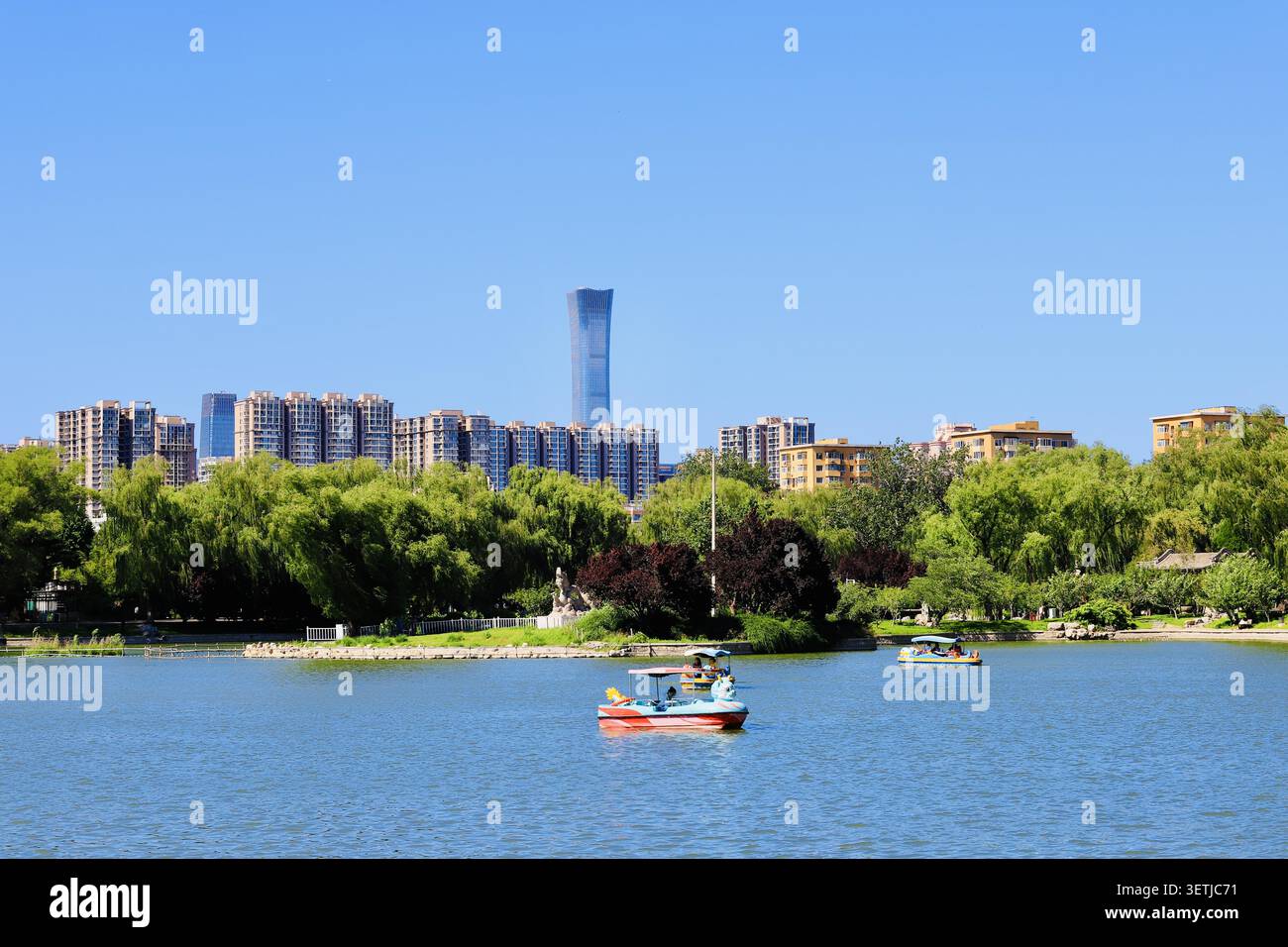 Visitors enjoy boating in Longtan Park with a view of China Zun in ...