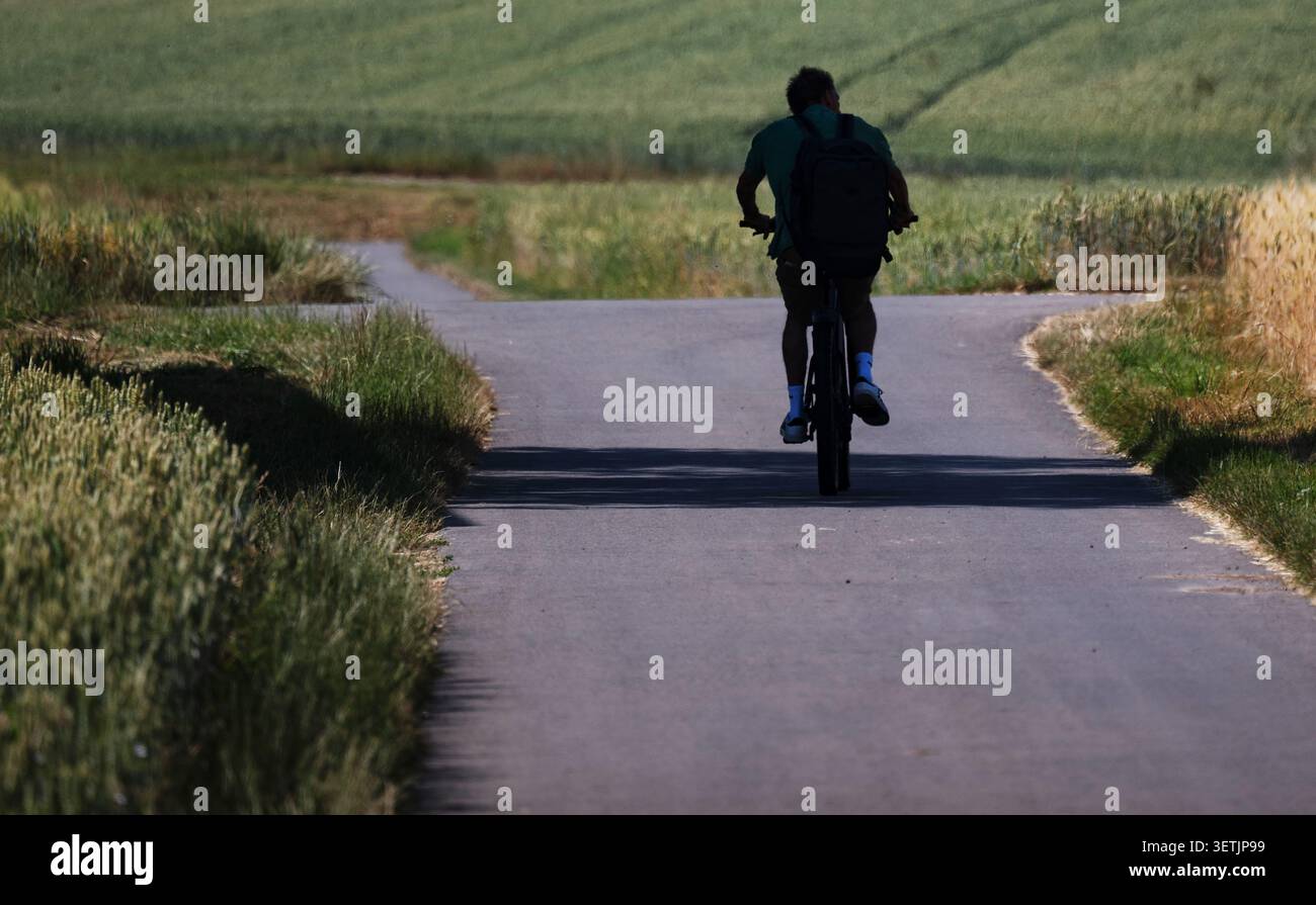 23 June 2026, Baden-Württemberg, Stuttgart: A cyclist rides through a ...