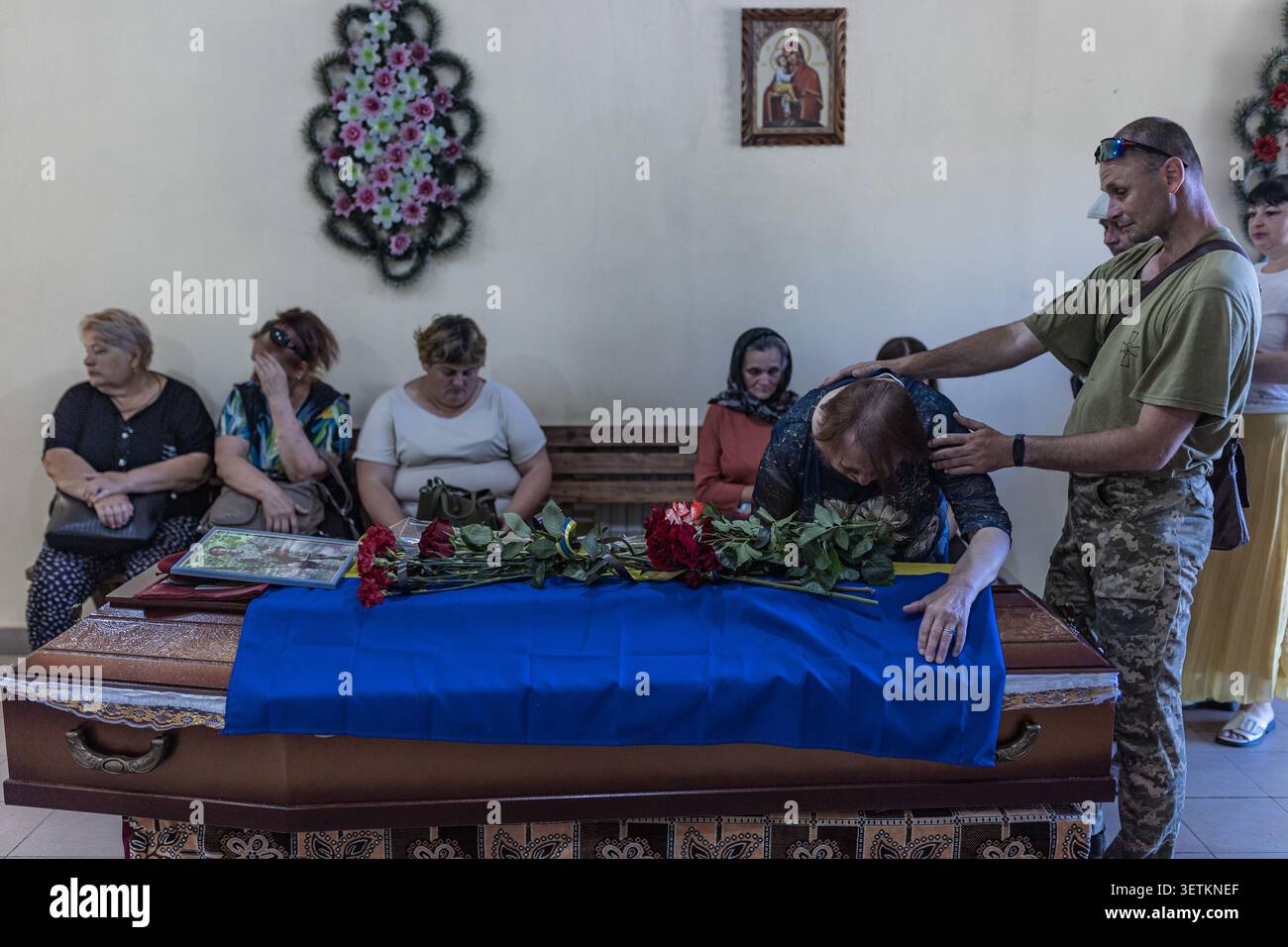 Relatives attend to the funeral of Roman Godina, a 39-year-old ...