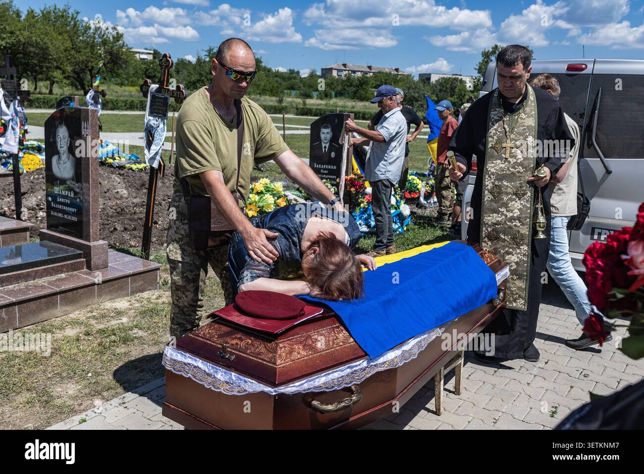 Relatives attend to the funeral of Roman Godina, a 39-year-old ...