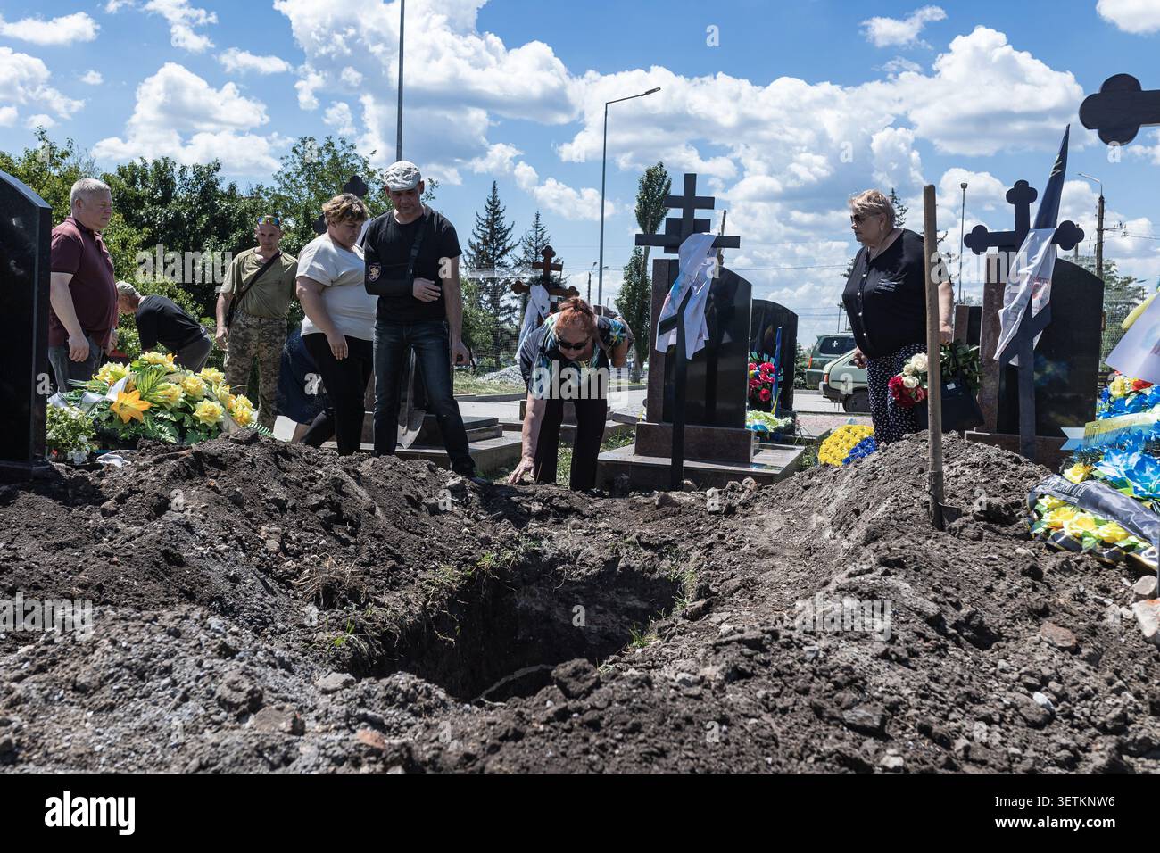 Relatives attend to the funeral of Roman Godina, a 39-year-old ...