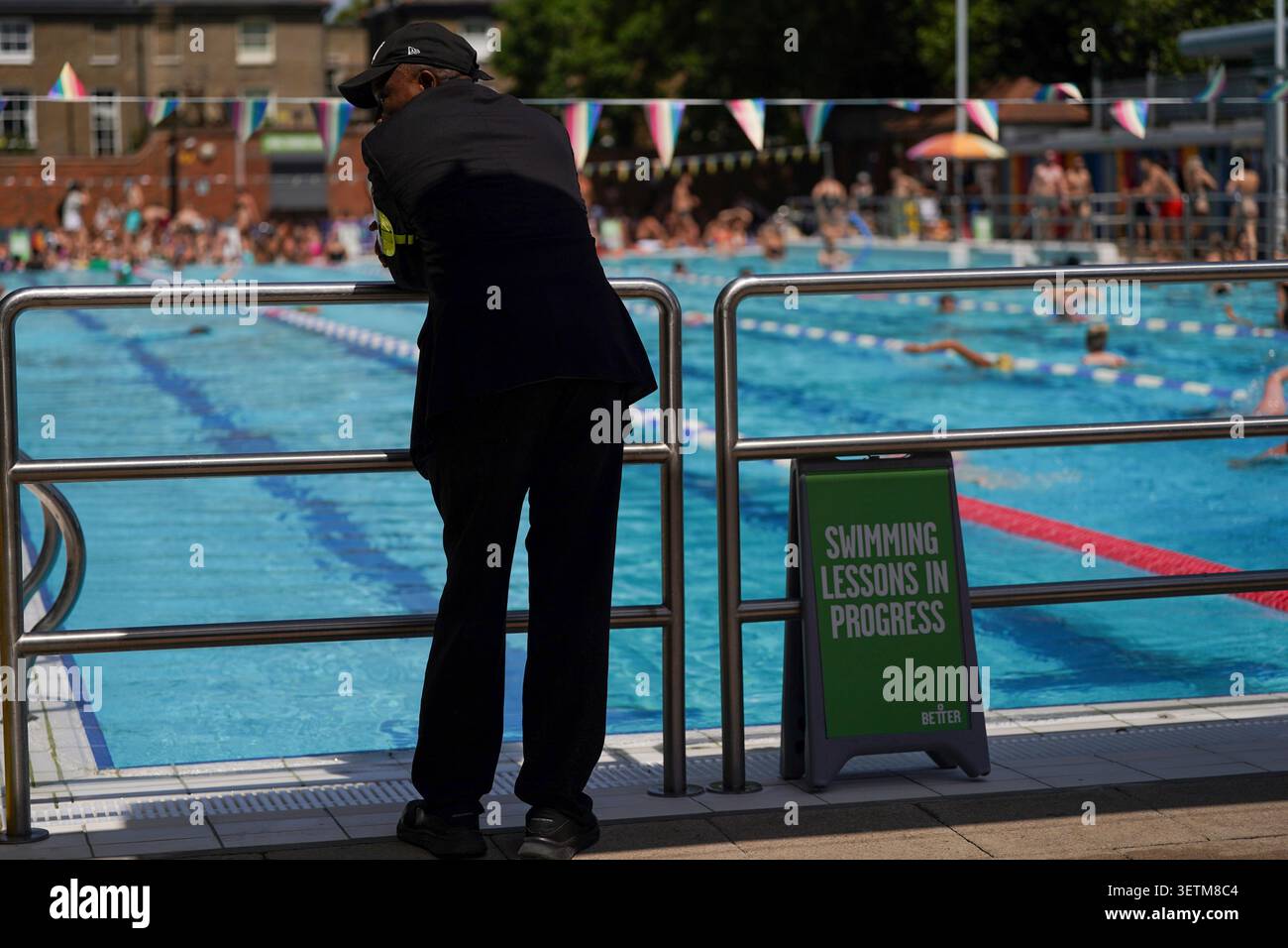 A security guard stands by an outdoor swimming pool in London, Tuesday ...