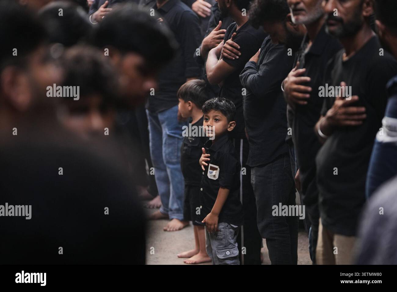 A child watches as Shiite Muslims flagellate themselves during a ...