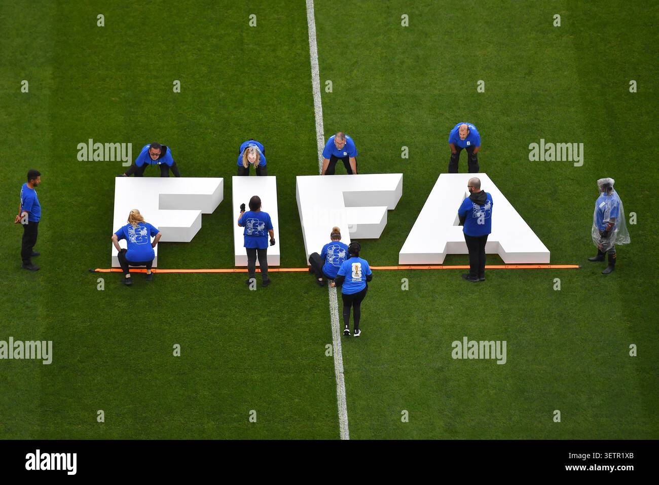Field officials place a FIFA logo on the field prior to the World Cup ...
