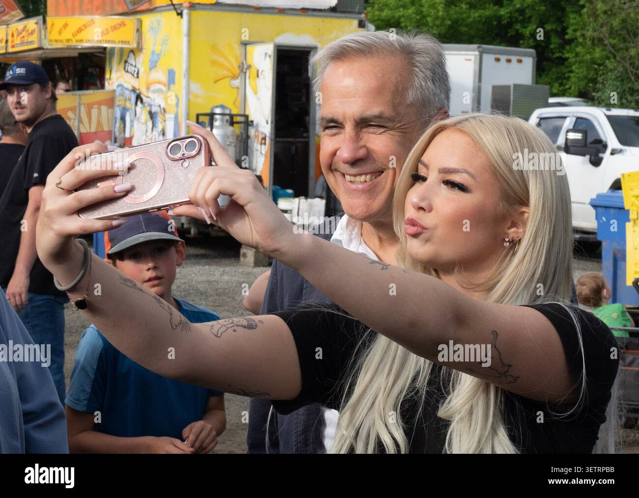 A woman poses for a self with Canada Prime Minister Mark Carney as he ...