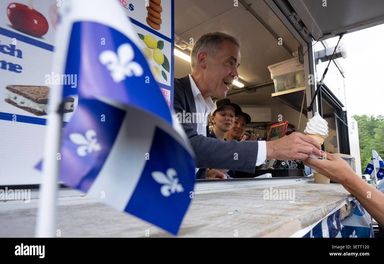 Prime Minister Mark Carney serves ice cream as he visits a Saint-Jean ...