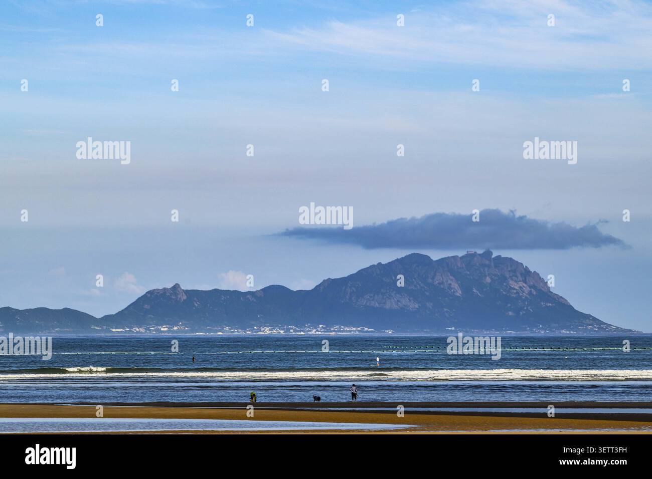 Tourists stroll along the shoreline of Lingshan Bay in Qingdao, east ...