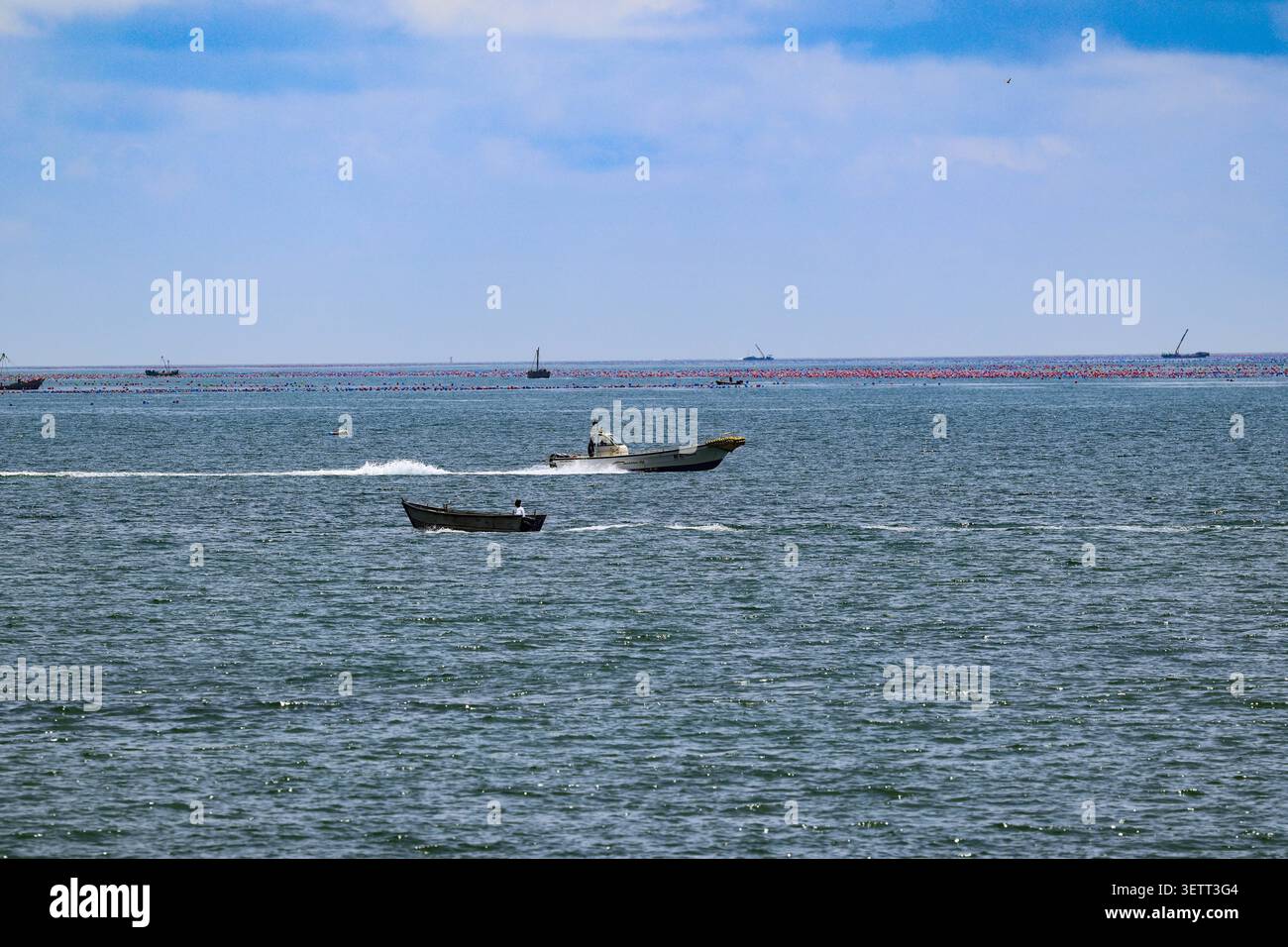 Tourists stroll along the shoreline of Lingshan Bay in Qingdao, east ...