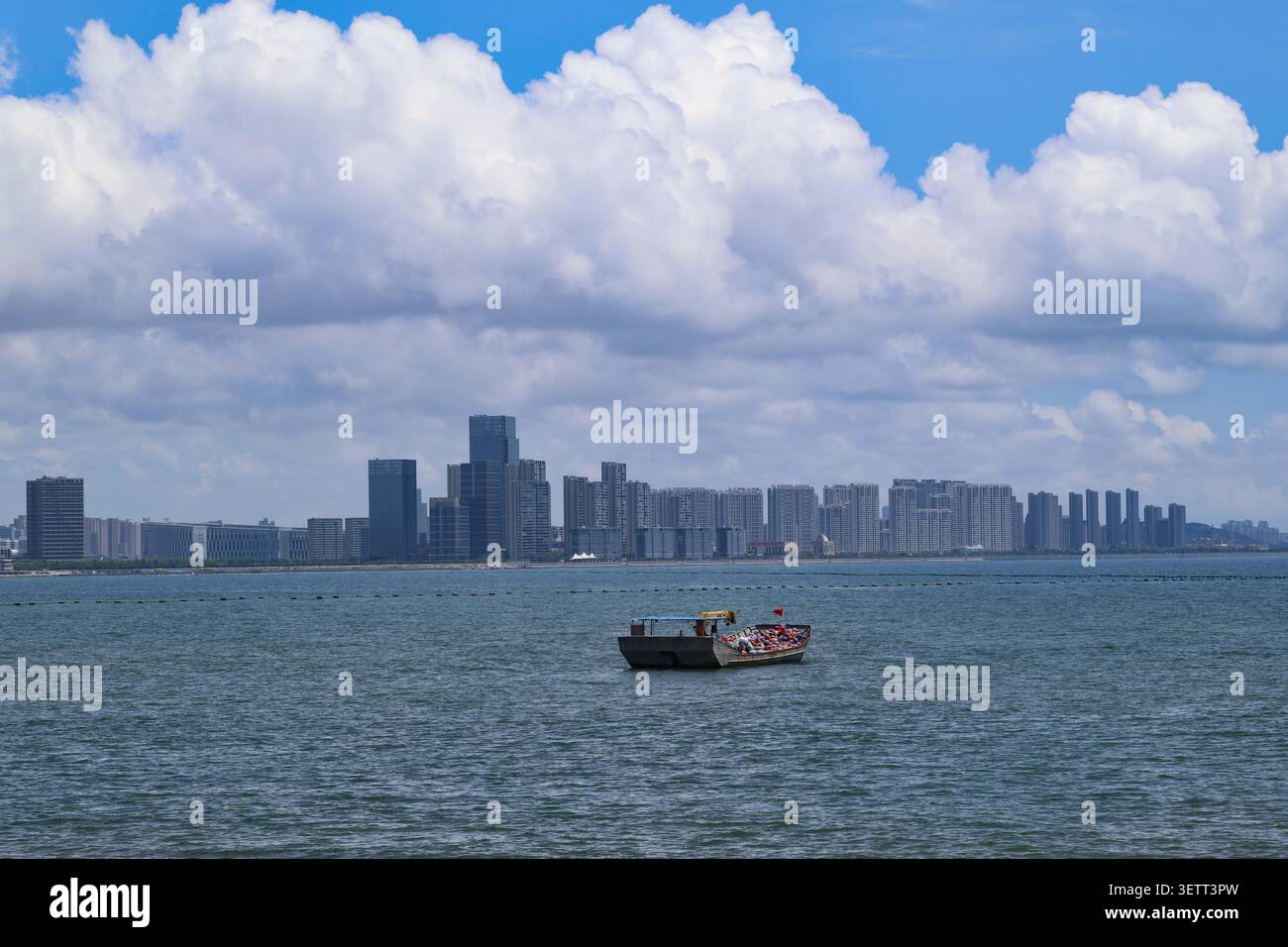Tourists stroll along the shoreline of Lingshan Bay in Qingdao, east ...