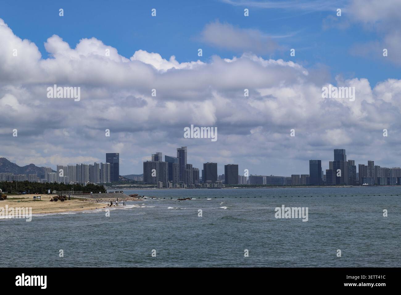 Tourists stroll along the shoreline of Lingshan Bay in Qingdao, east ...