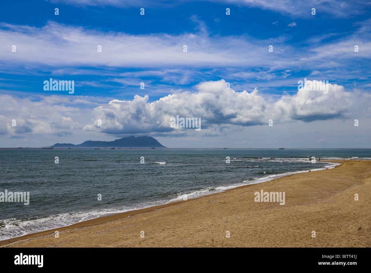 Tourists stroll along the shoreline of Lingshan Bay in Qingdao, east ...